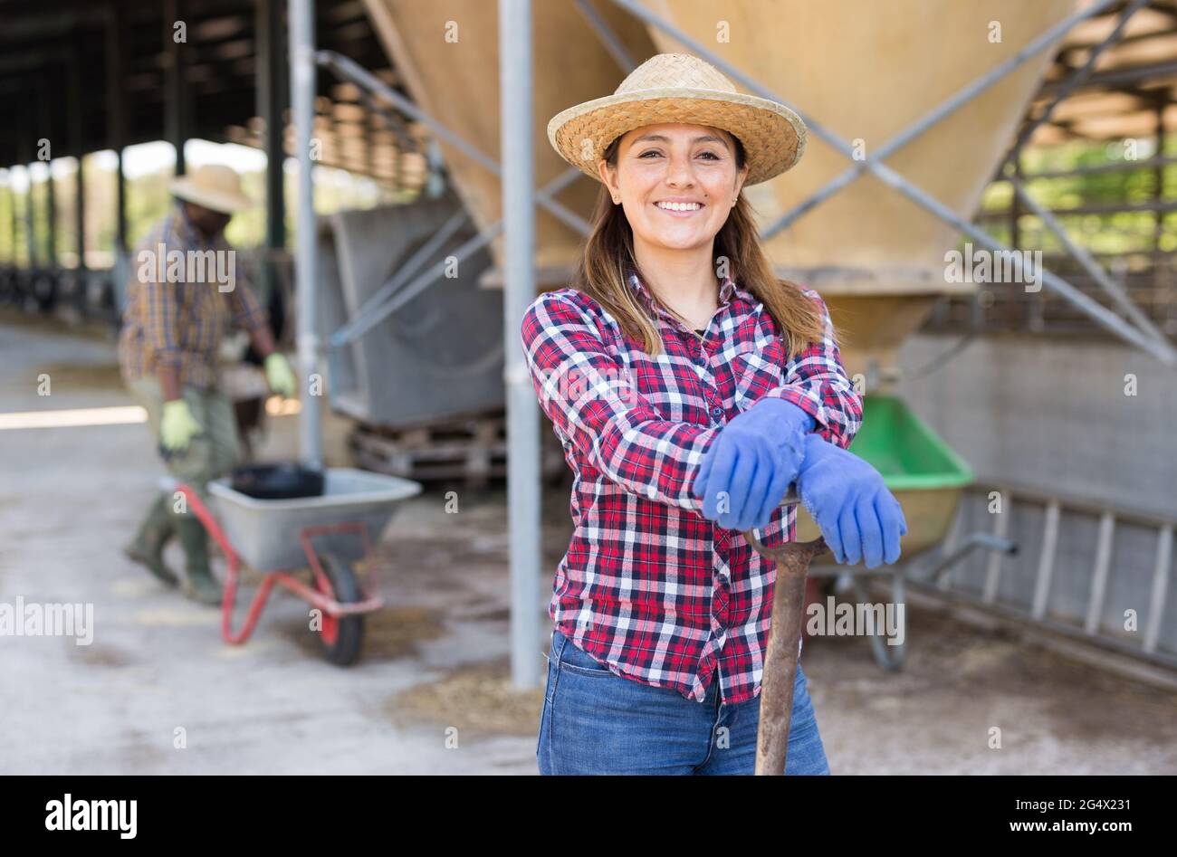 Positive young woman owner of dairy farm standing in stall Stock Photo ...
