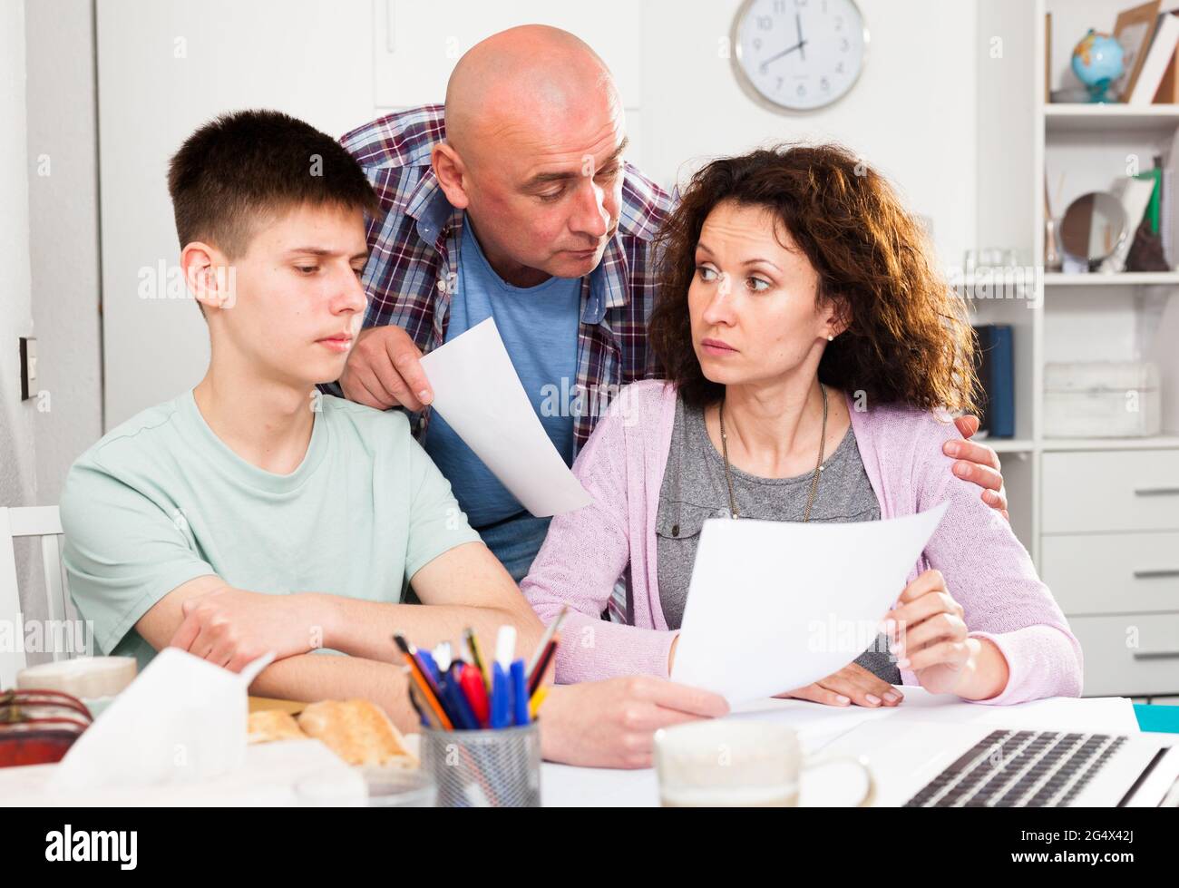 Parents with teenager son reading documents Stock Photo - Alamy