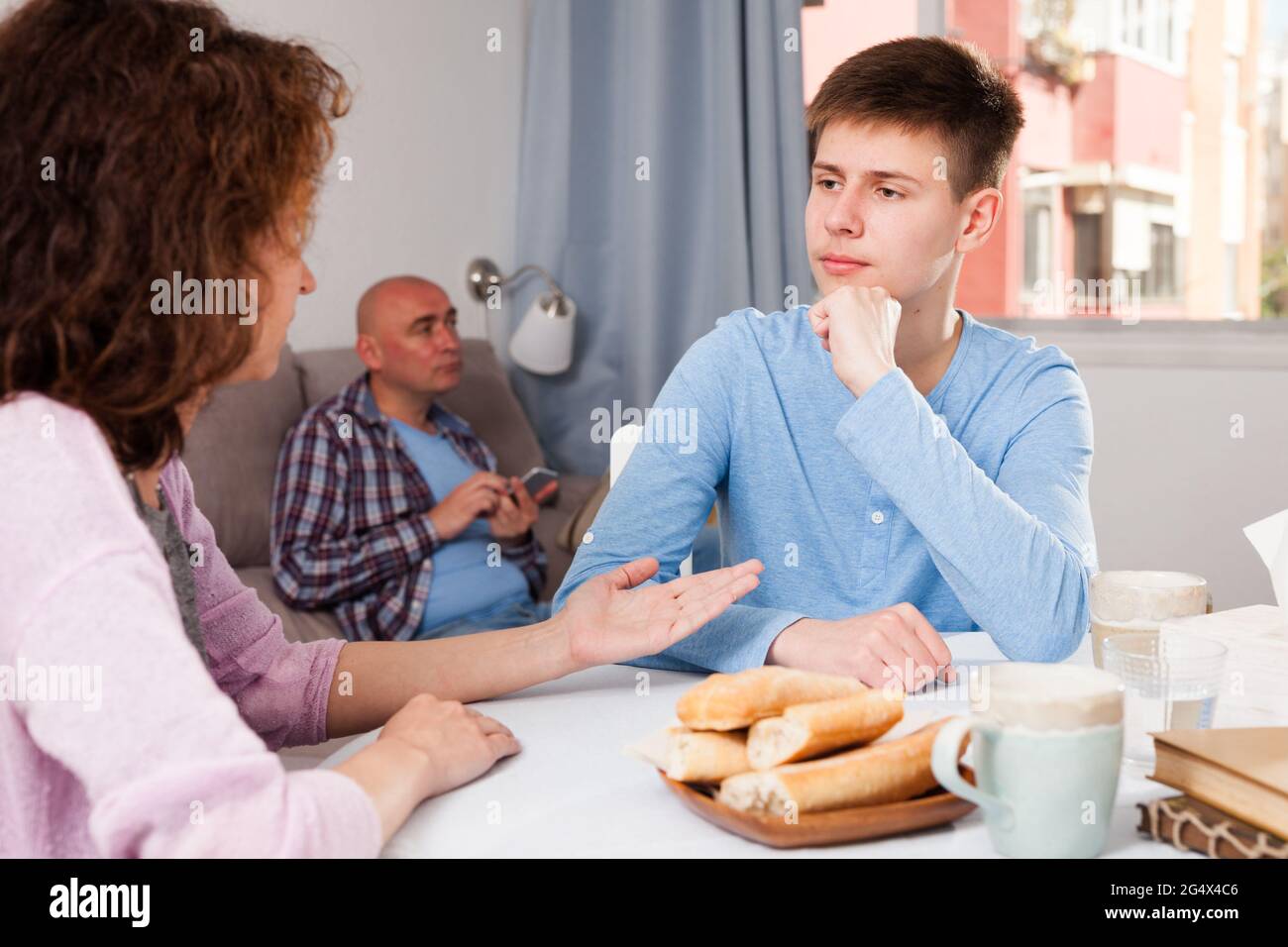 Boy talking to mother on background with indifferent father Stock Photo ...