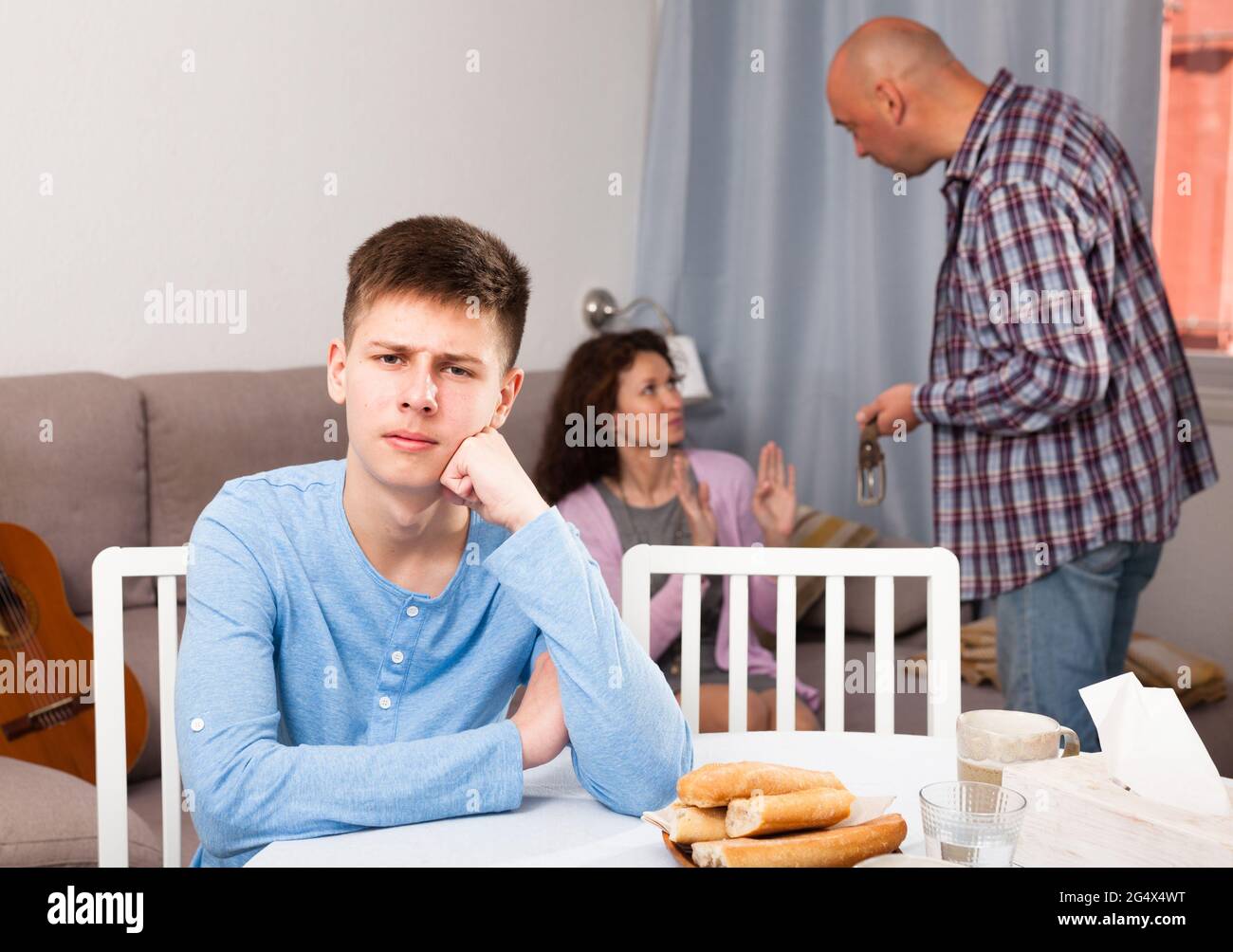 Unhappy teen boy with quarreling parents Stock Photo - Alamy