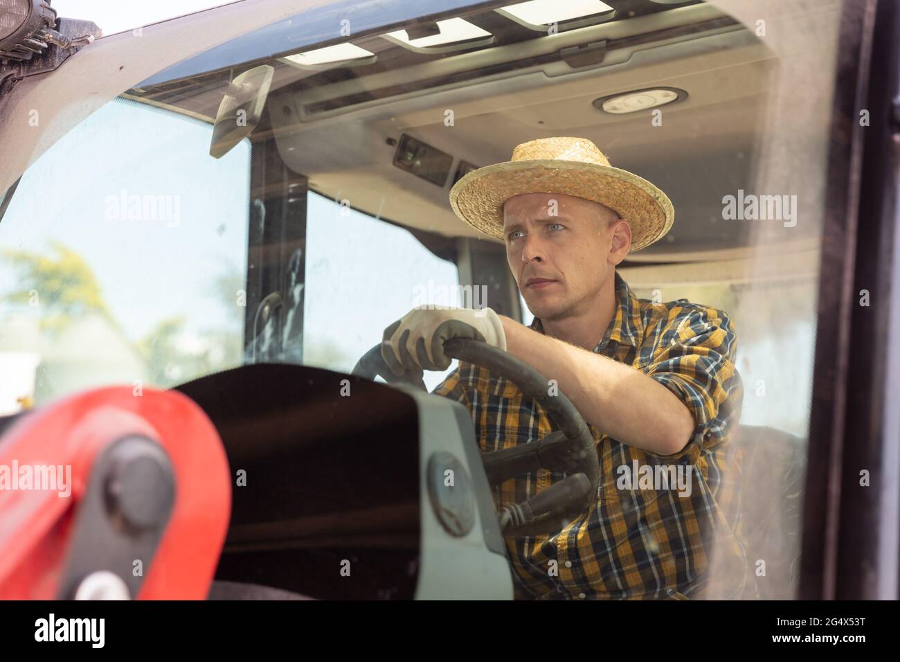Focused busy farmer driving tractor working on farm Stock Photo - Alamy