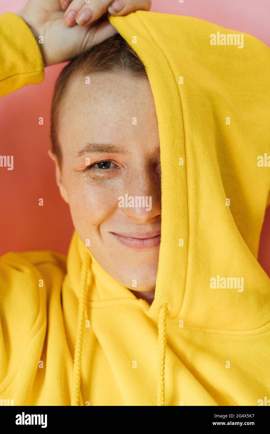 Young woman covering half face with hoodie in studio Stock Photo - Alamy
