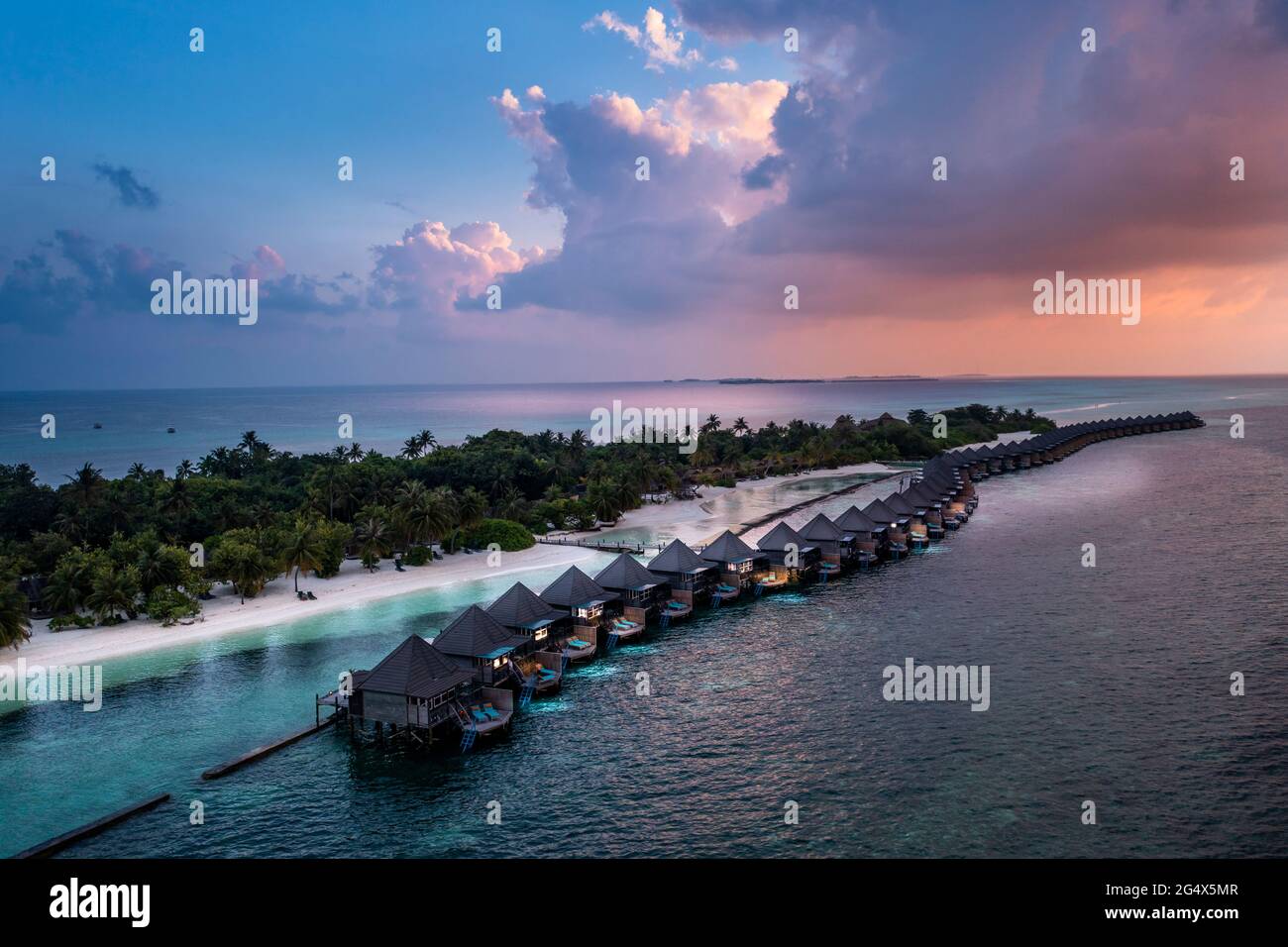 Stilt houses by sea at Kuredu Island during sunset, Maldives, Asia ...