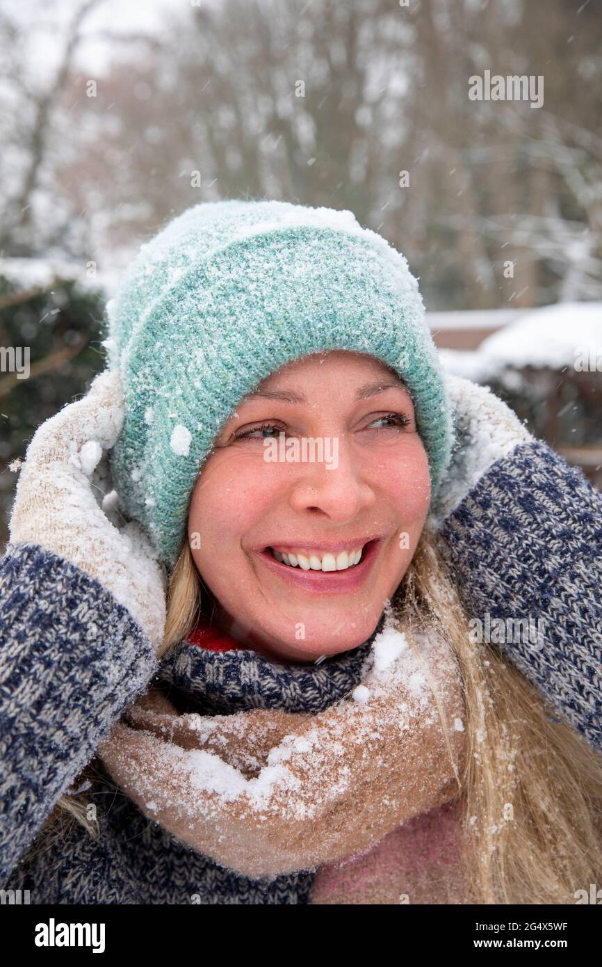 Mature woman wearing knit hat laughing while looking away Stock Photo ...
