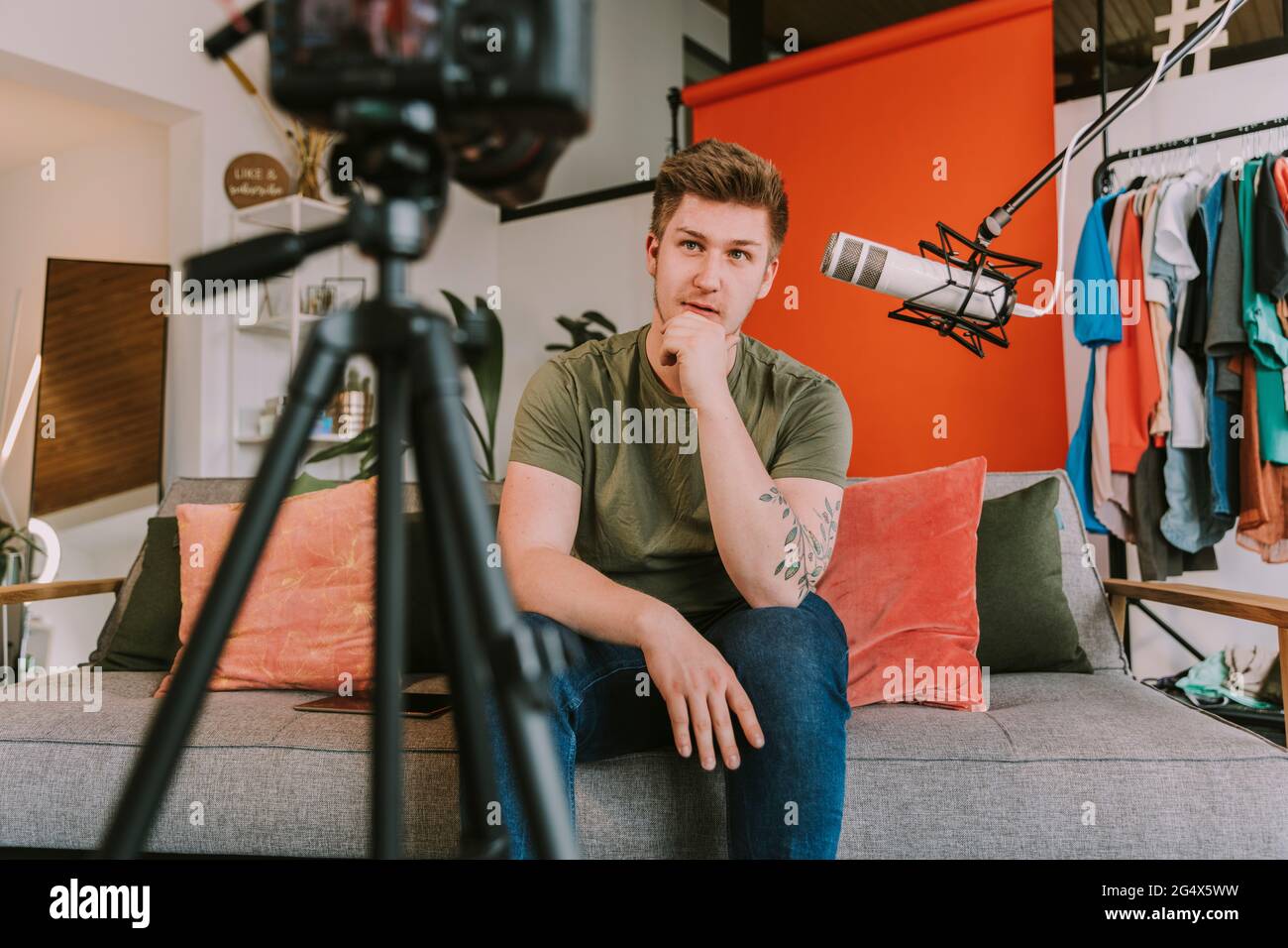 Male gamer with hand on chin vlogging at home Stock Photo - Alamy