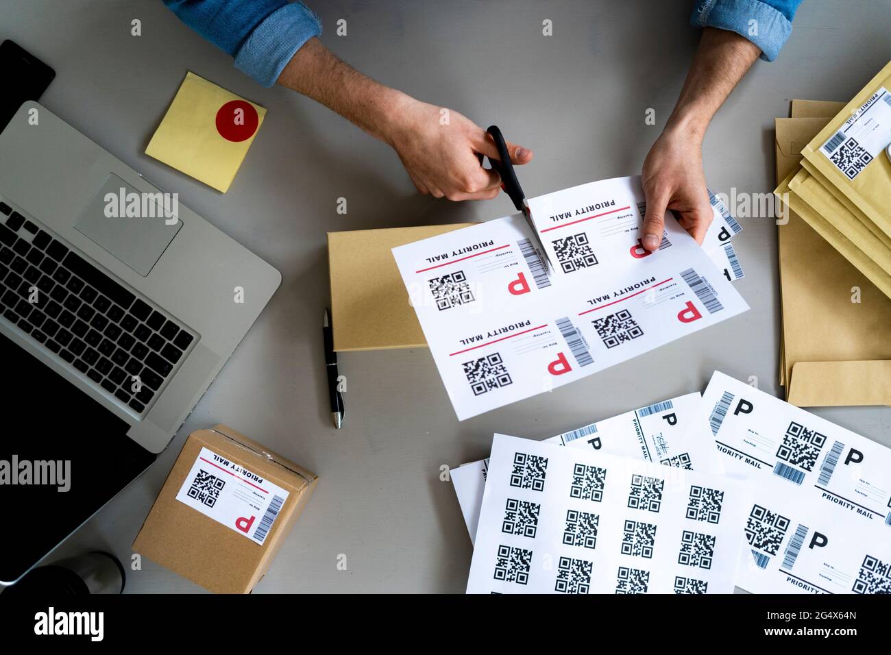 Male entrepreneur cutting QR code label at desk Stock Photo - Alamy