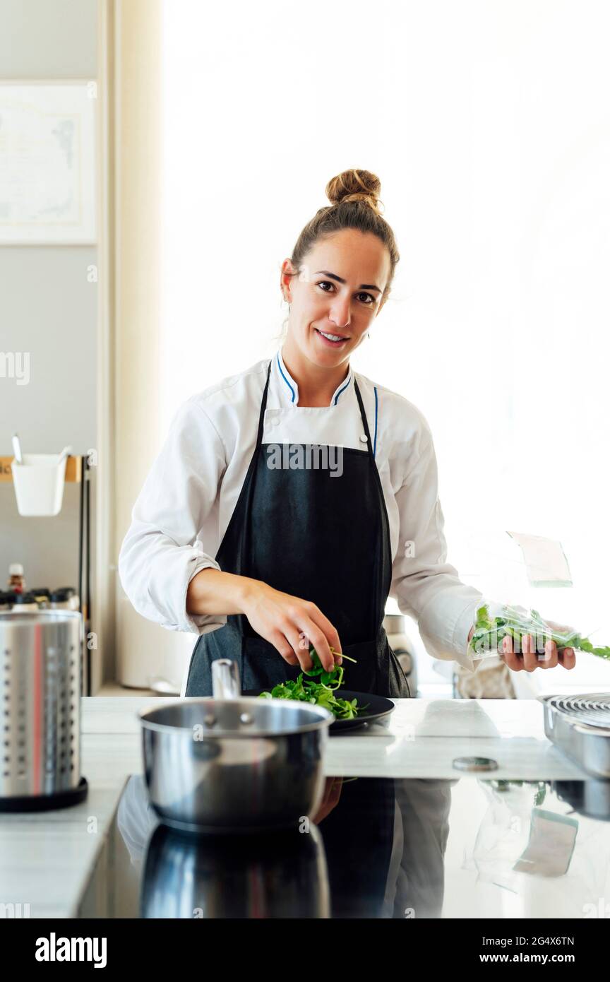 Portrait of a smiling female cook preparing food in the kitchen Stock ...