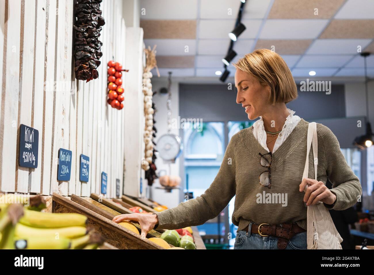 Woman checking fruit kept in retail display at supermarket Stock Photo ...
