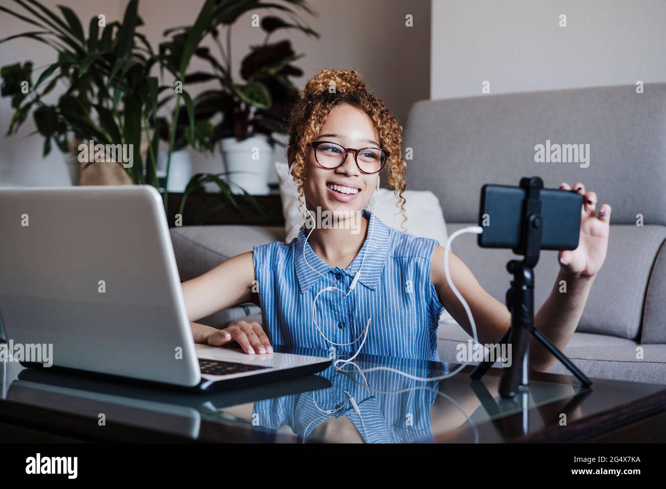 Smiling female professional talking during video conference through ...