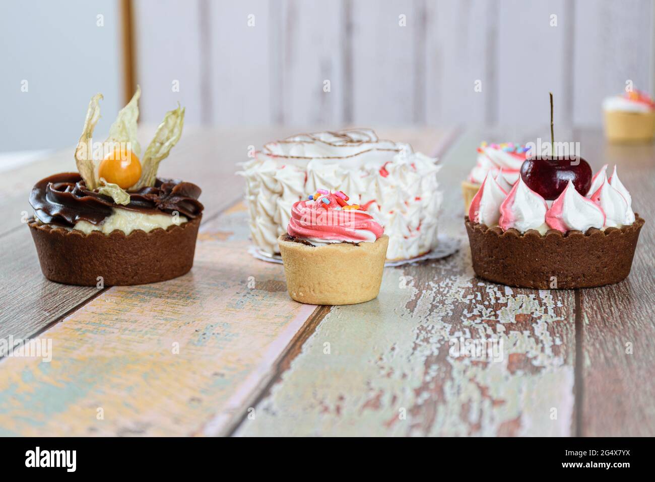 Mini sablée pastry pies with whipped cream topping, alongside mini ...