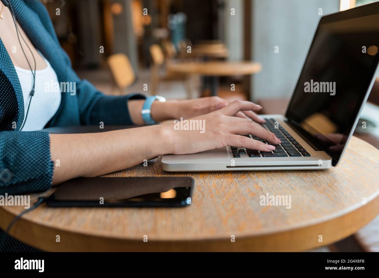 Female freelance worker using laptop in cafe Stock Photo - Alamy