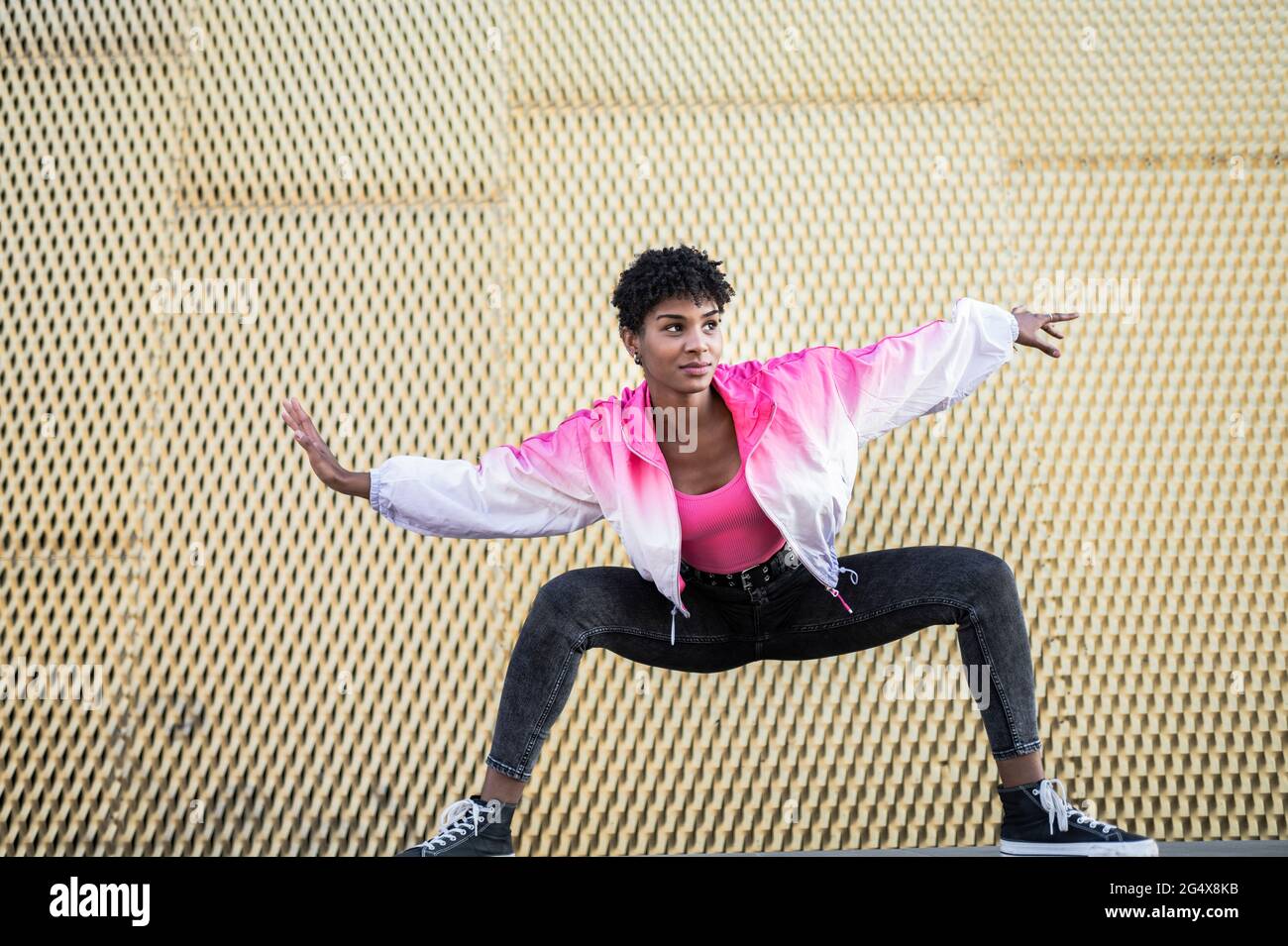 Beautiful woman looking away while dancing outdoors Stock Photo - Alamy