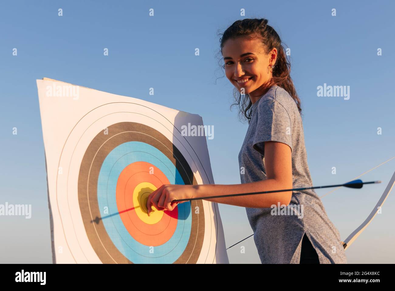 Smiling archeress removing arrow from bull's eye Stock Photo - Alamy Smiling archeress removing arrow from bull's eye Stock Photo - Alamy