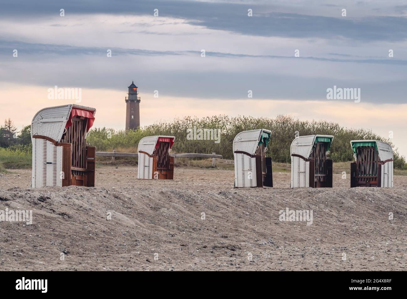 Hooded beach chairs standing on empty beach at dusk with Neuland ...