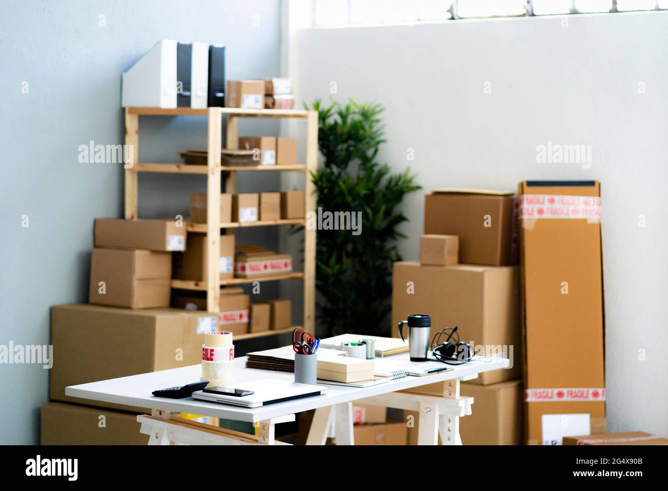 Packages by desk in warehouse Stock Photo - Alamy