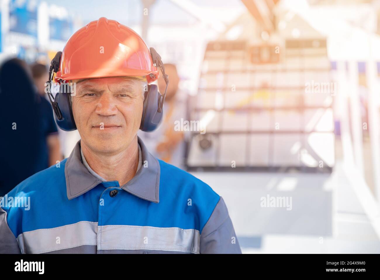 Industrial worker engineer man in protective helmet and headphones in ...