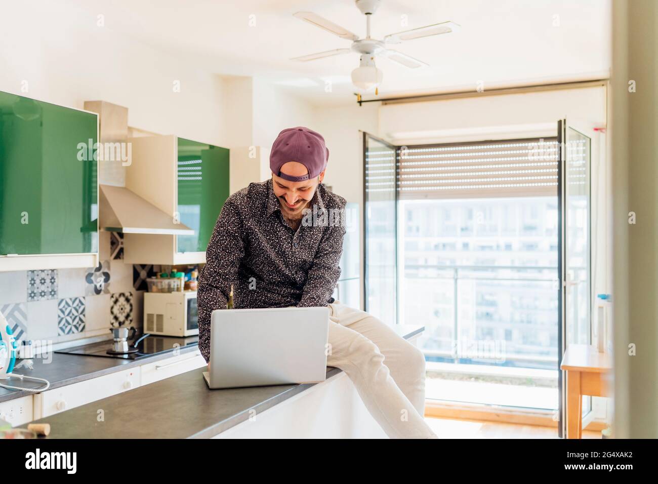 Man on laptop at kitchen island hi-res stock photography and images - Alamy