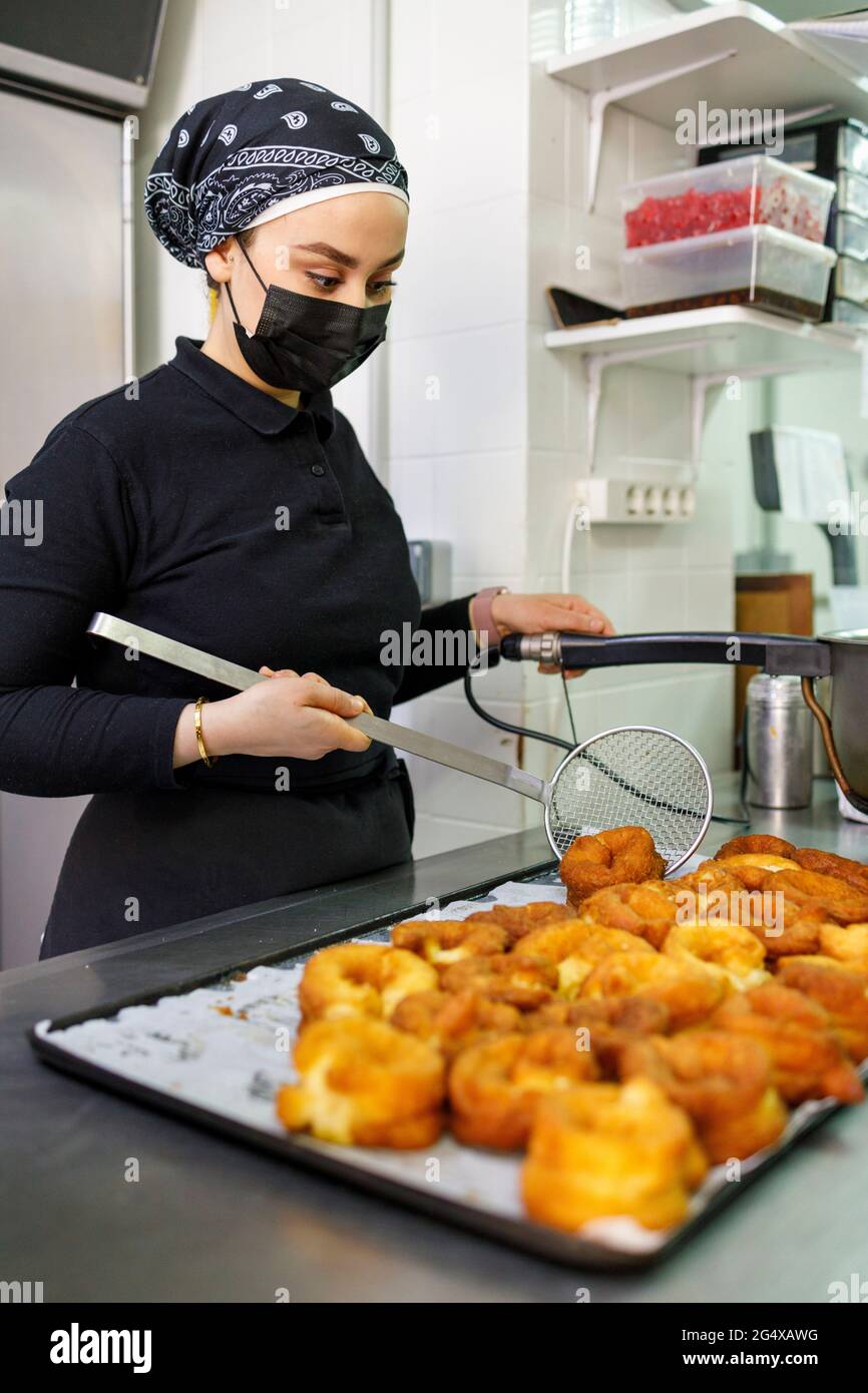 Female chef making doughnuts in bakery Stock Photo - Alamy