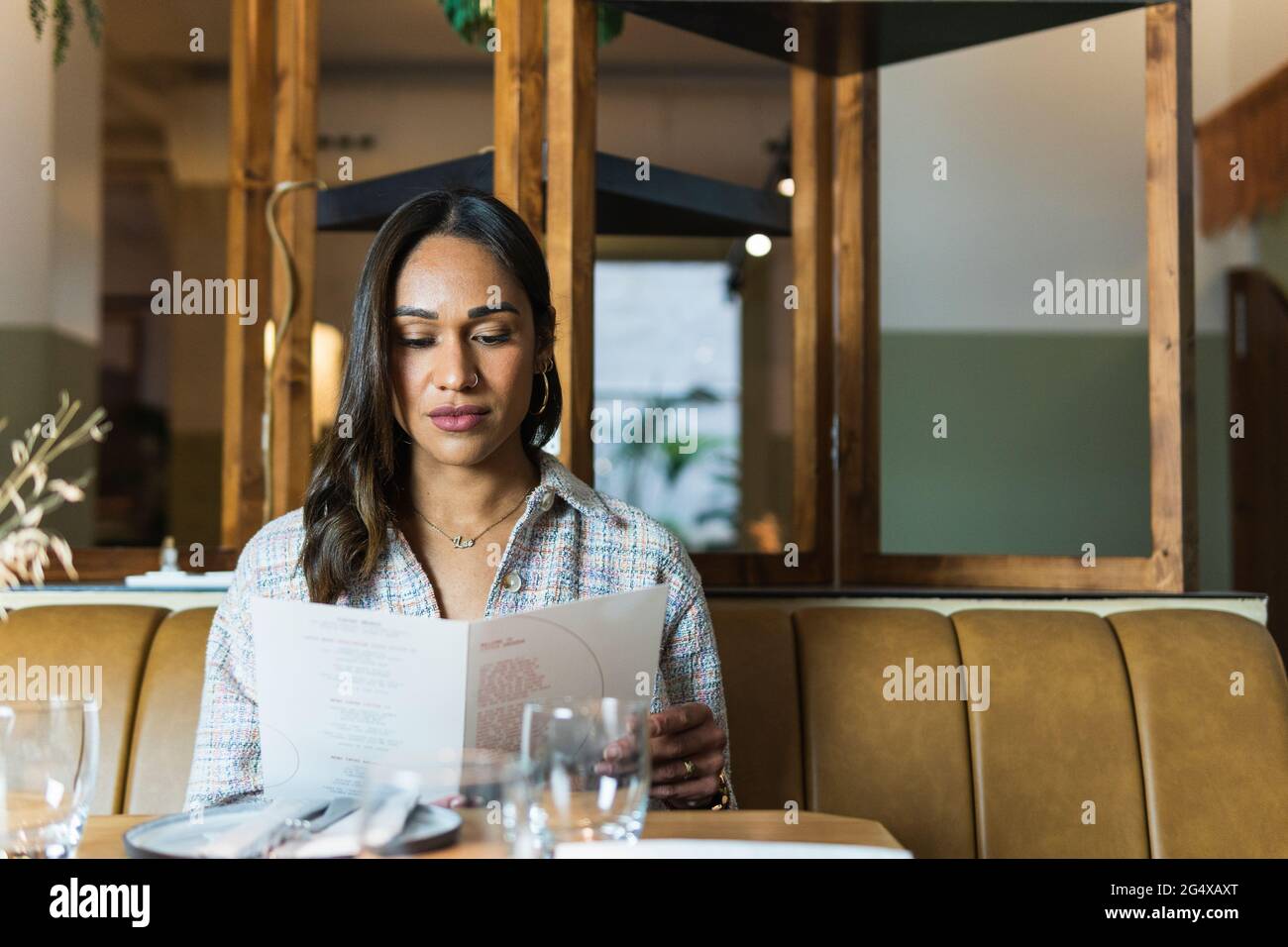 Young woman reading menu in restaurant Stock Photo - Alamy