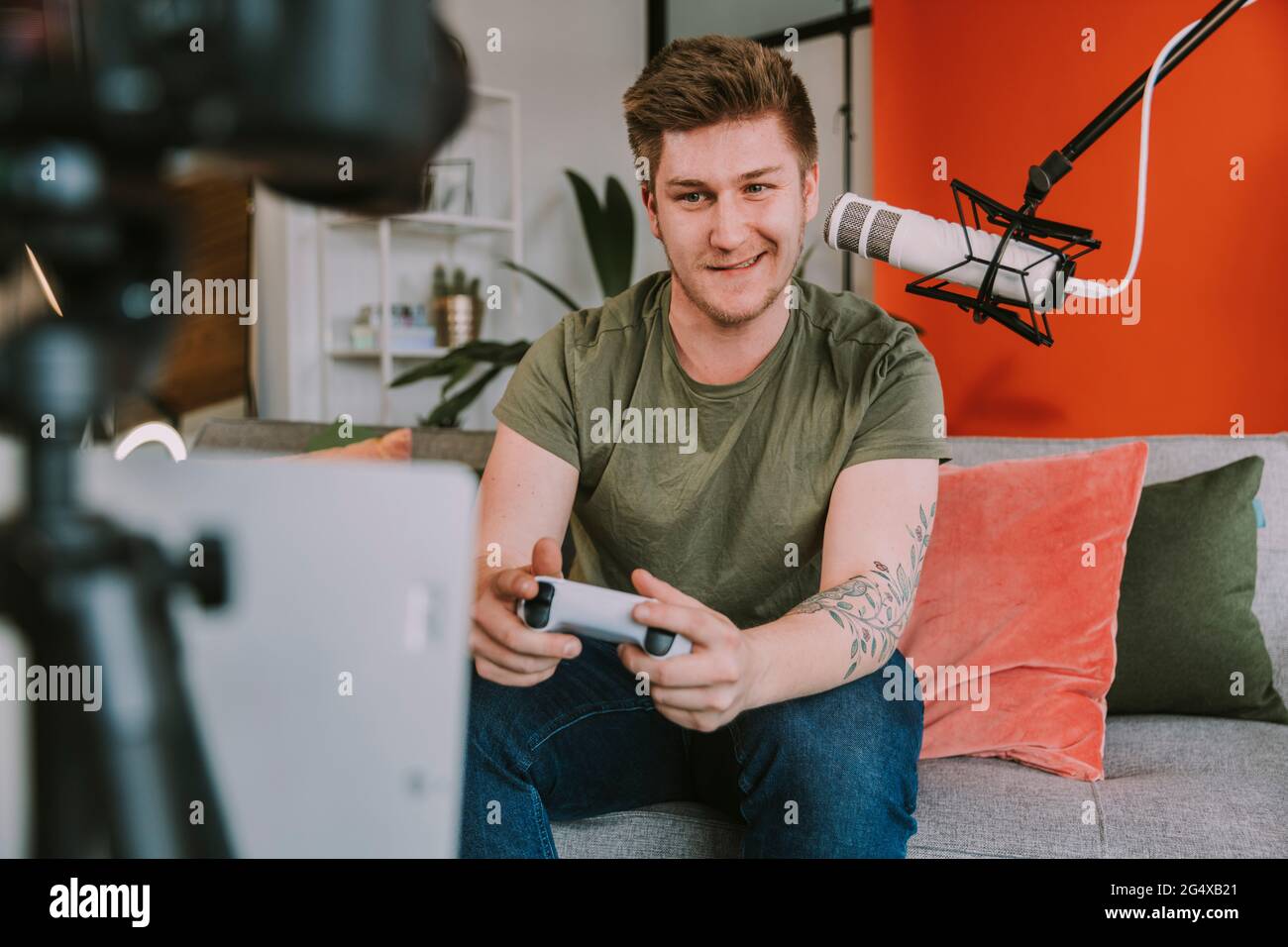 Male gamer playing video game while vlogging at home Stock Photo - Alamy