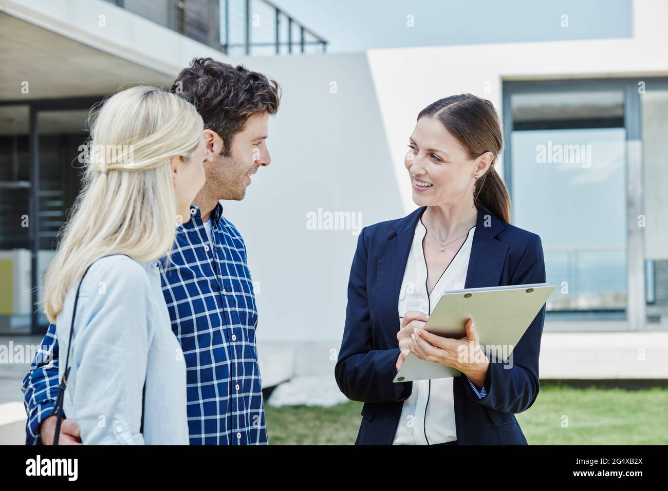 Customer having discussion with female real estate agent in front of ...