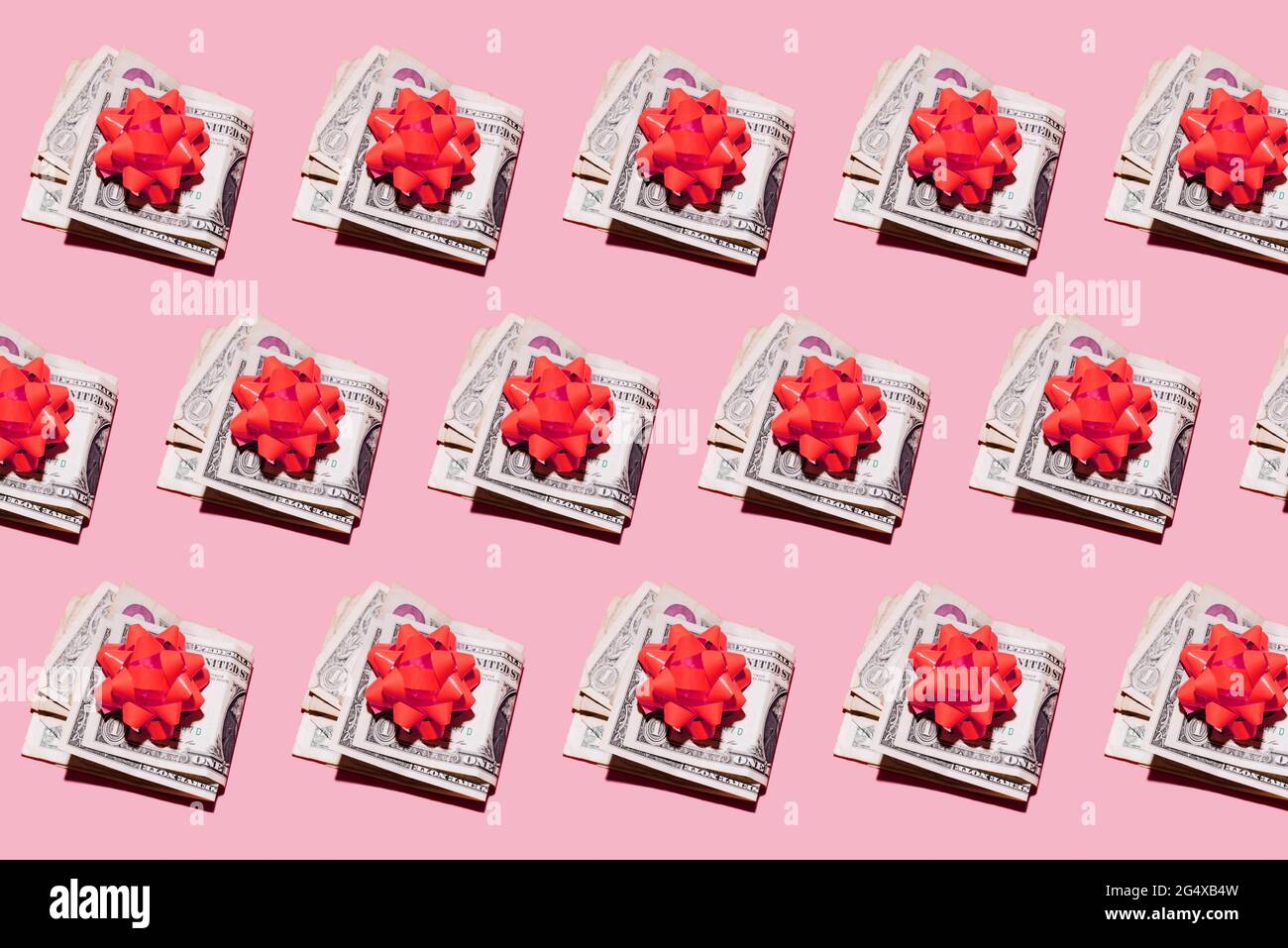 Pattern of rows of folded dollar bills with red gift bows Stock Photo ...