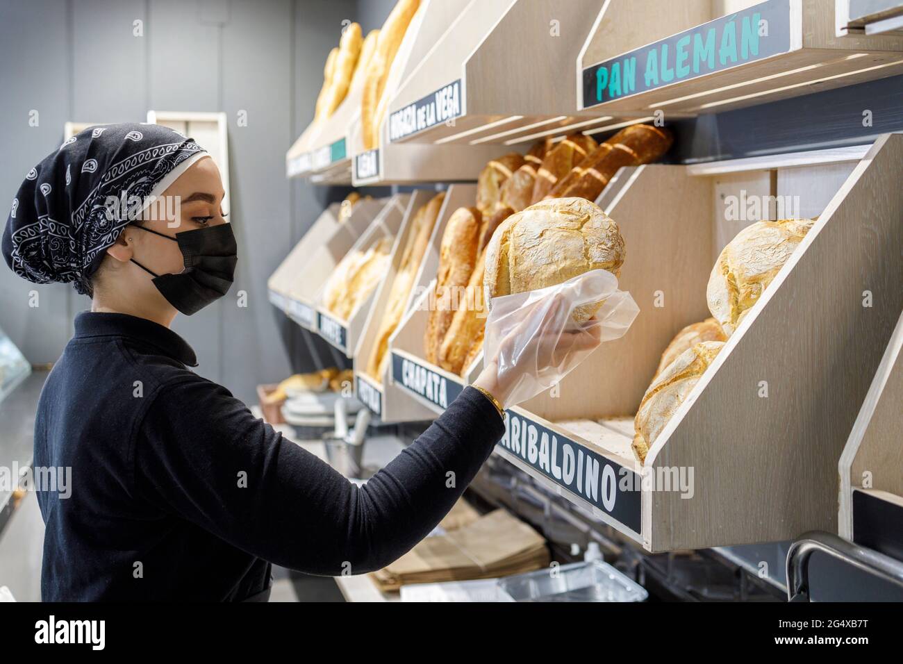 Female baker wearing mask working in bakery Stock Photo - Alamy