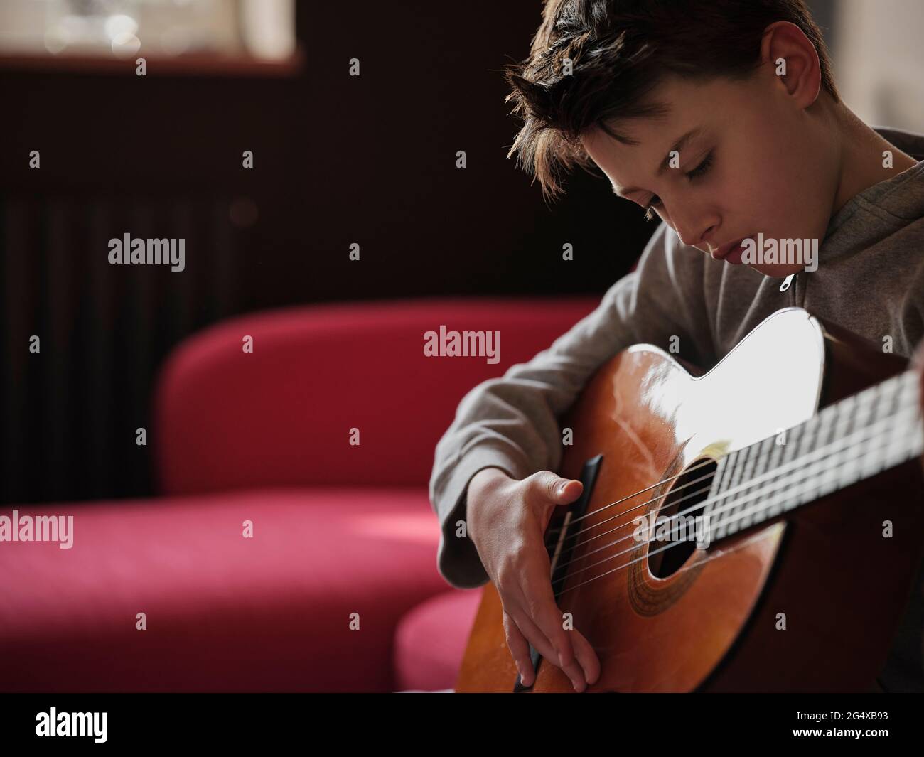 Boy learning guitar at home Stock Photo - Alamy