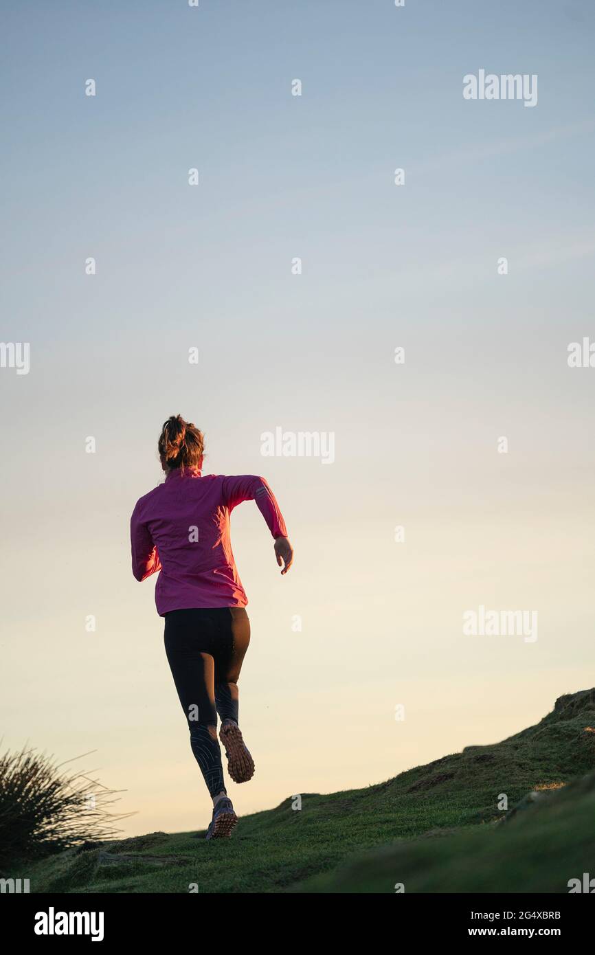 Woman running on hill Stock Photo - Alamy