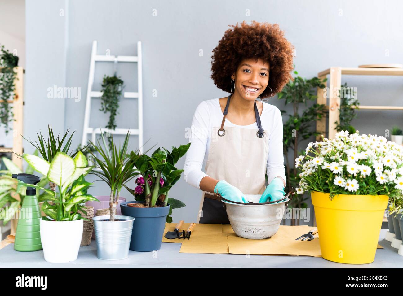 Female shop owner smiling while working at flower shop Stock Photo - Alamy