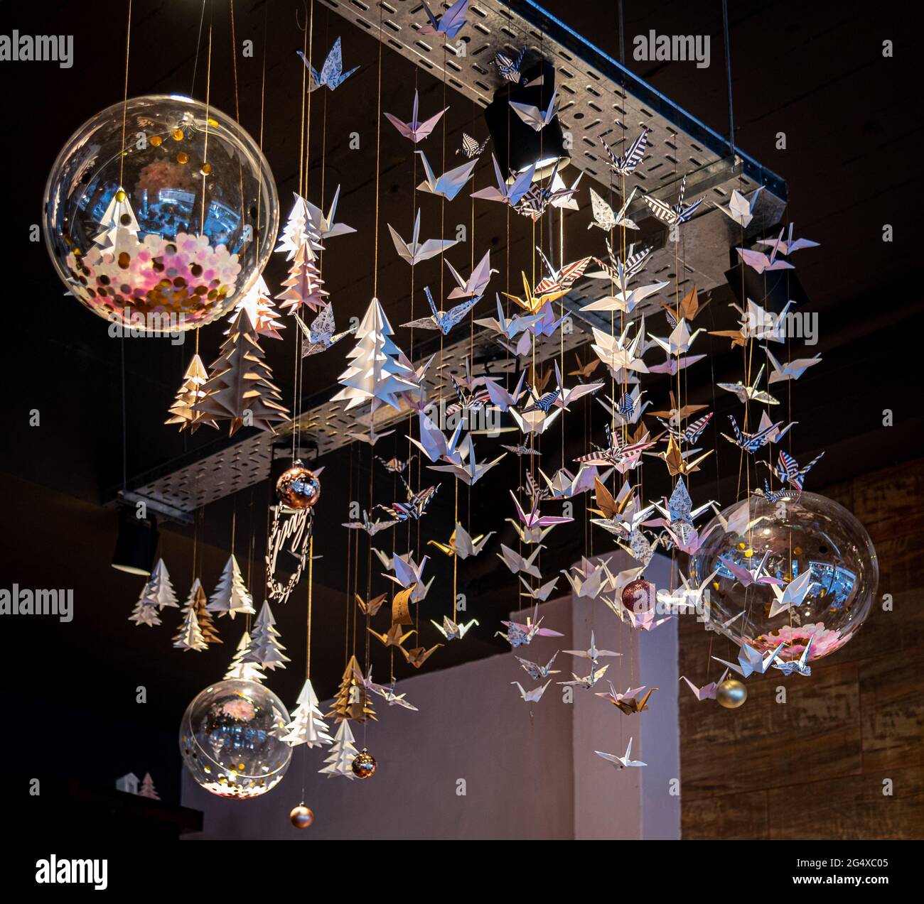 Lots of origami swans hanging from the roof, seen from underneath in a ...