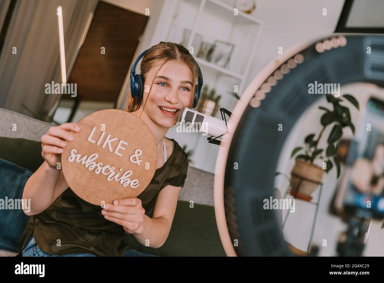 Female influencer showing like and subscribe sign while vlogging at ...