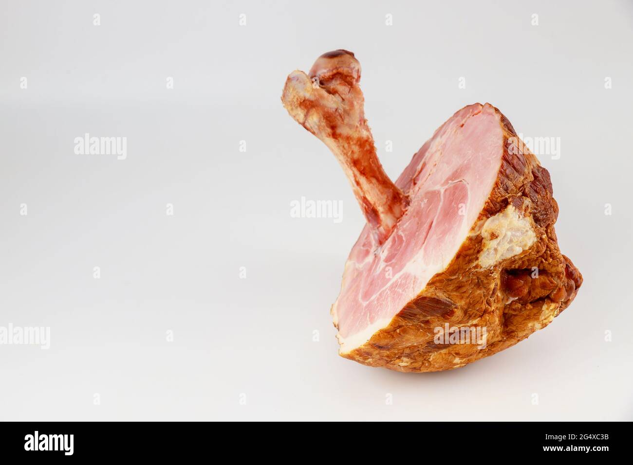 Honey glazed pork ham with big bone on white background Stock Photo - Alamy