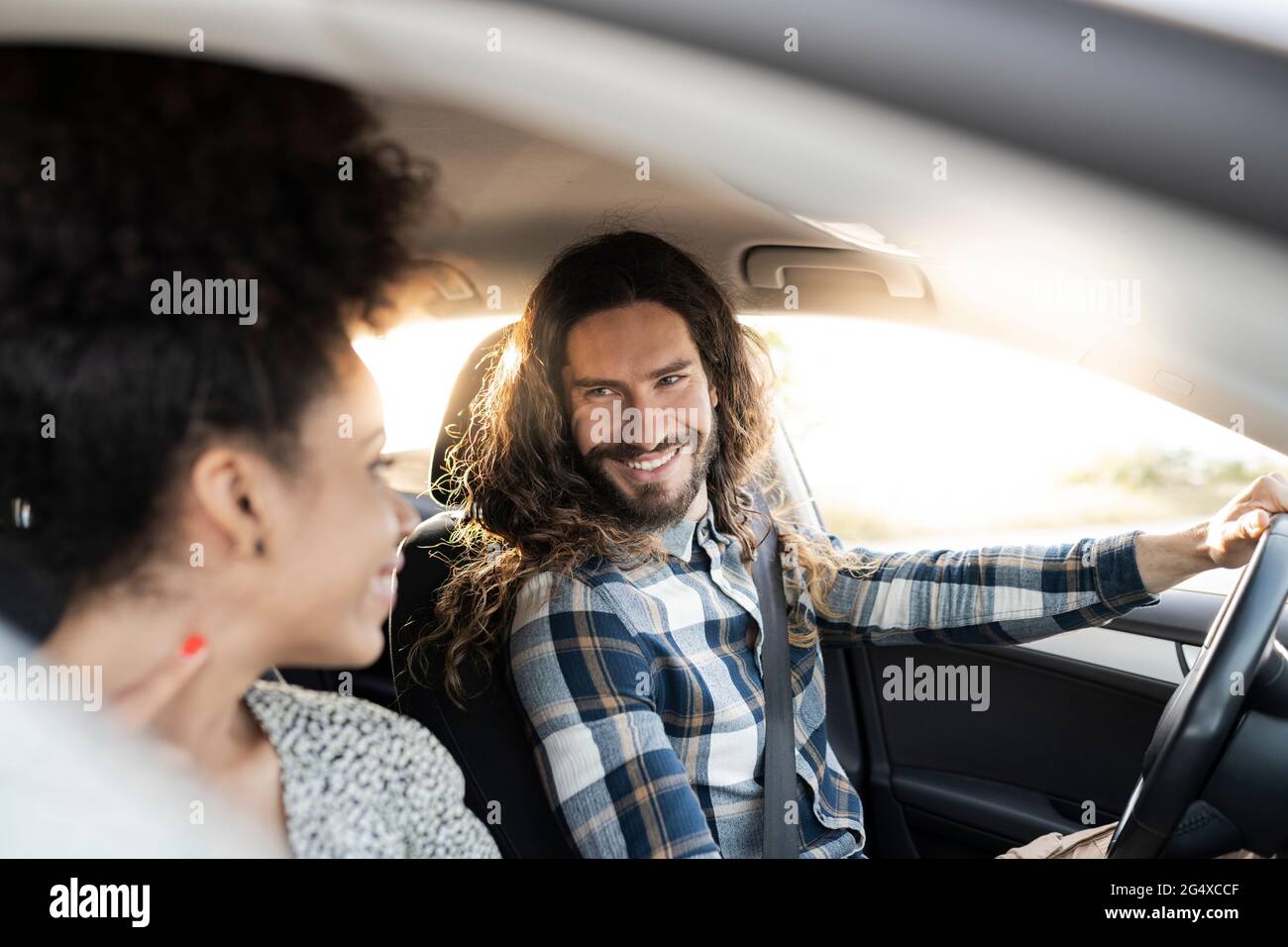 Smiling boyfriend looking at girlfriend while driving car Stock Photo ...