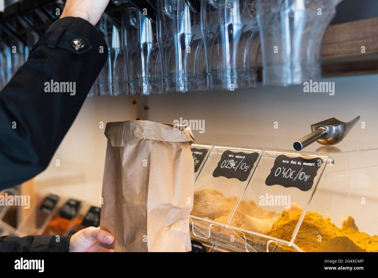 Woman filling spices in paper bag at supermarket Stock Photo - Alamy