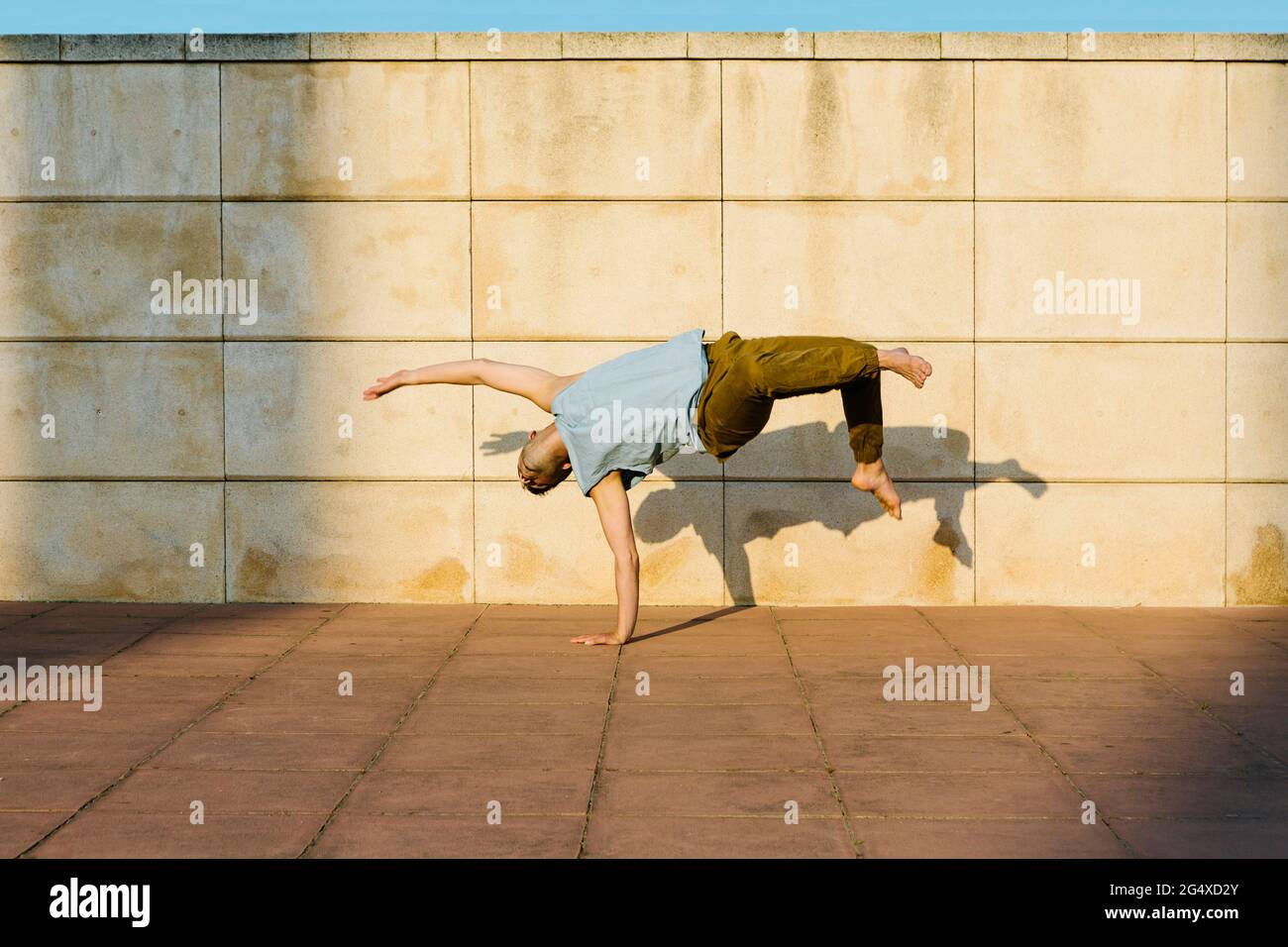 Male dancer balancing on hand in front of wall Stock Photo - Alamy