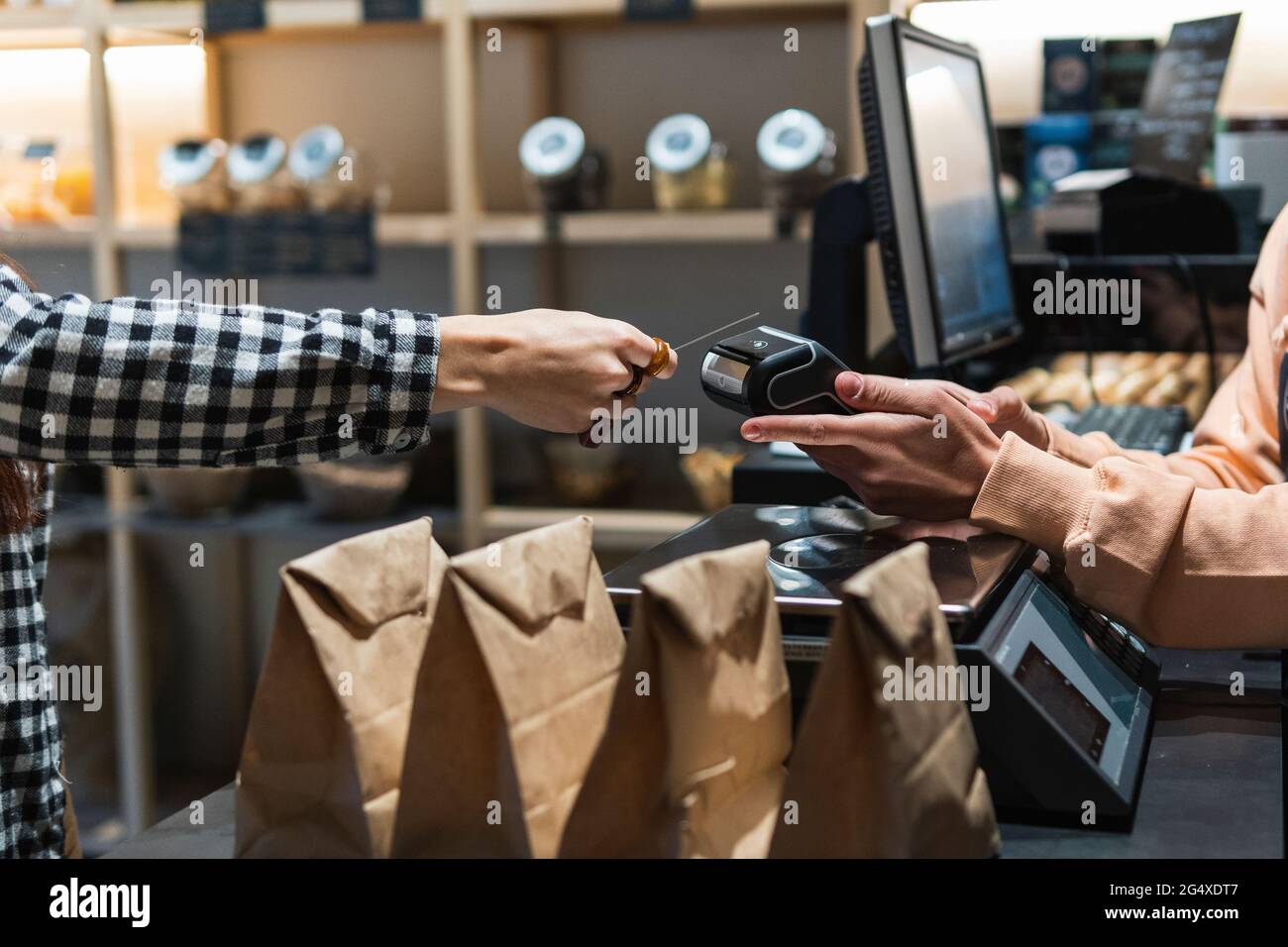 Female owner with card reader receiving payment from customer at ...