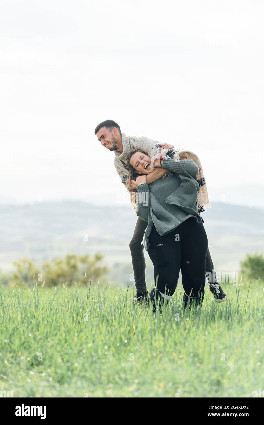 Playful girlfriend and boyfriend having fun at field Stock Photo - Alamy