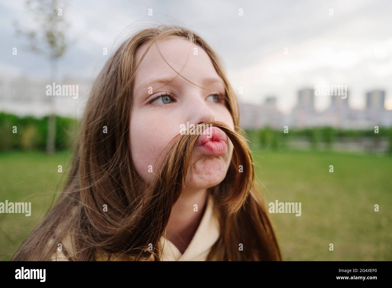 Funny girl playing with hair in public park Stock Photo - Alamy