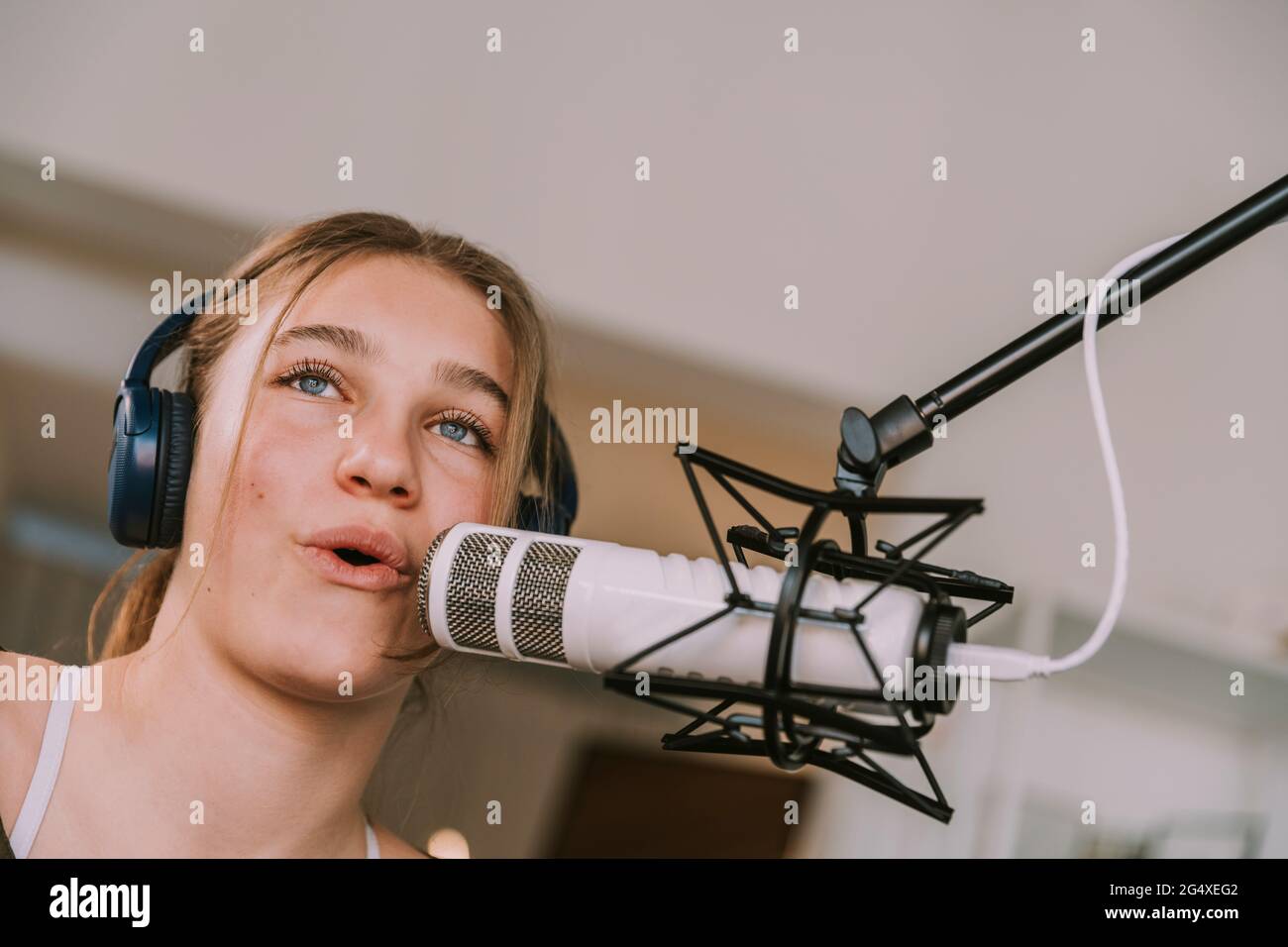 Female singer looking away while singing on microphone Stock Photo - Alamy