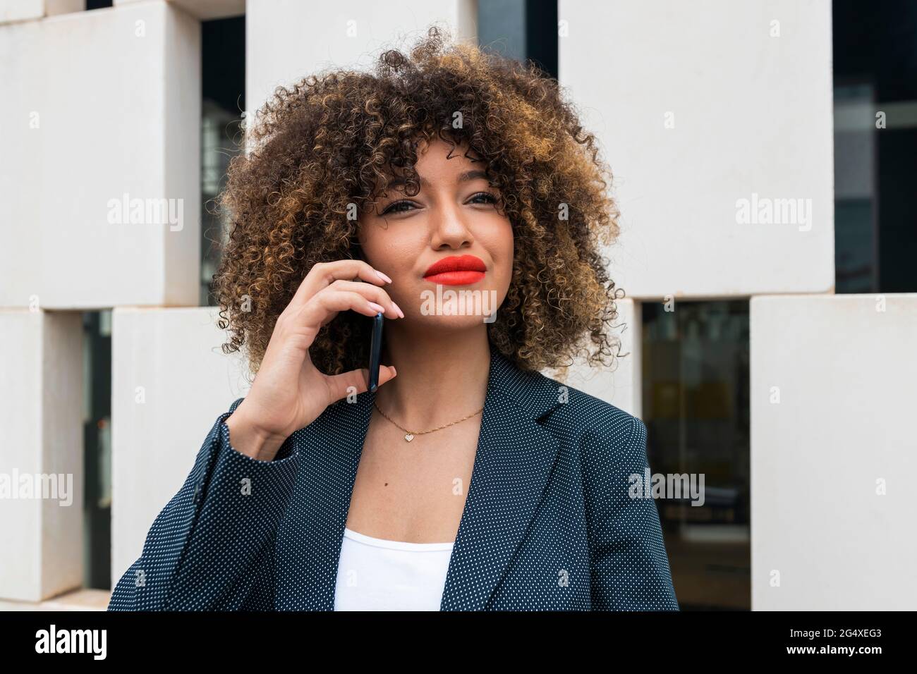 Beautiful female professional talking on mobile phone in front of ...