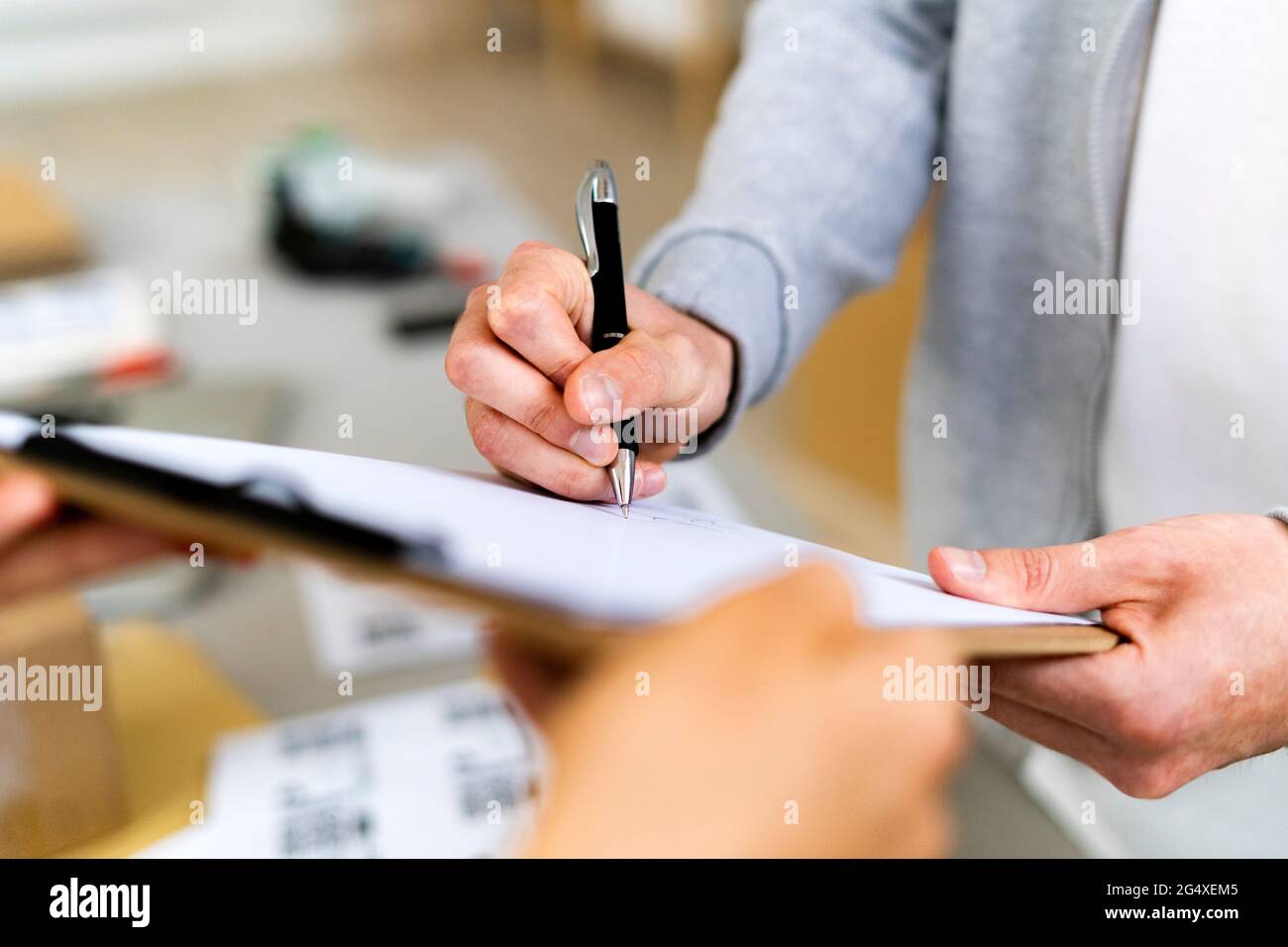 Female customer signing on document after receiving package in ...