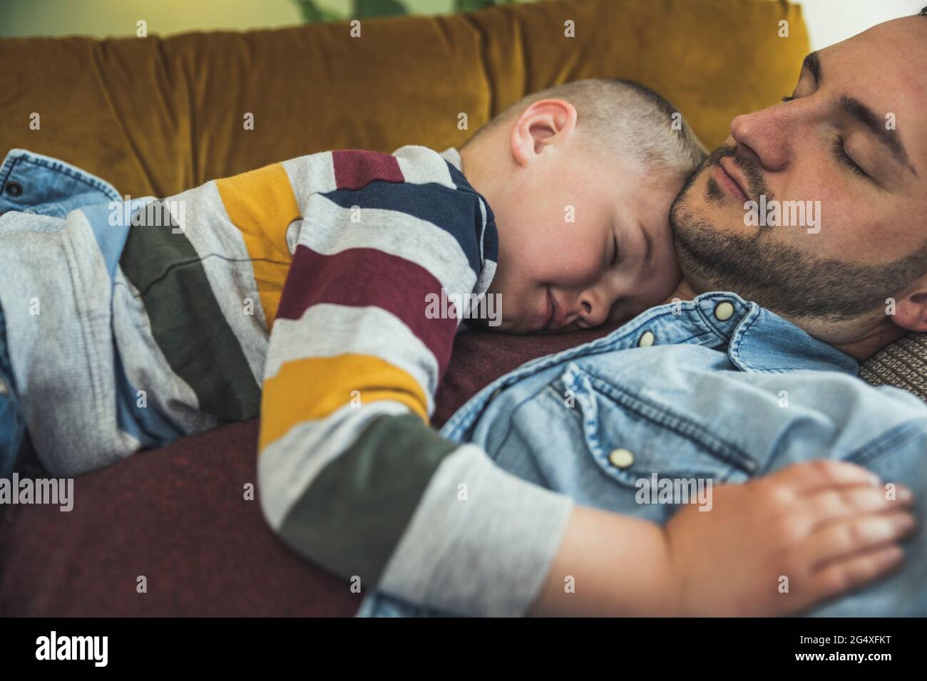 Father and son sleeping on sofa in living room at home Stock Photo - Alamy