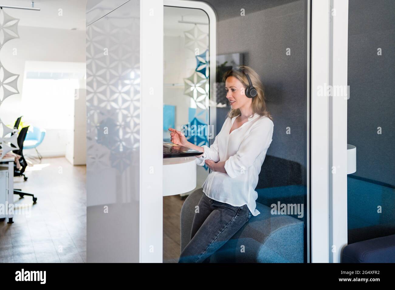 Female customer service representative working in soundproof cabin at ...