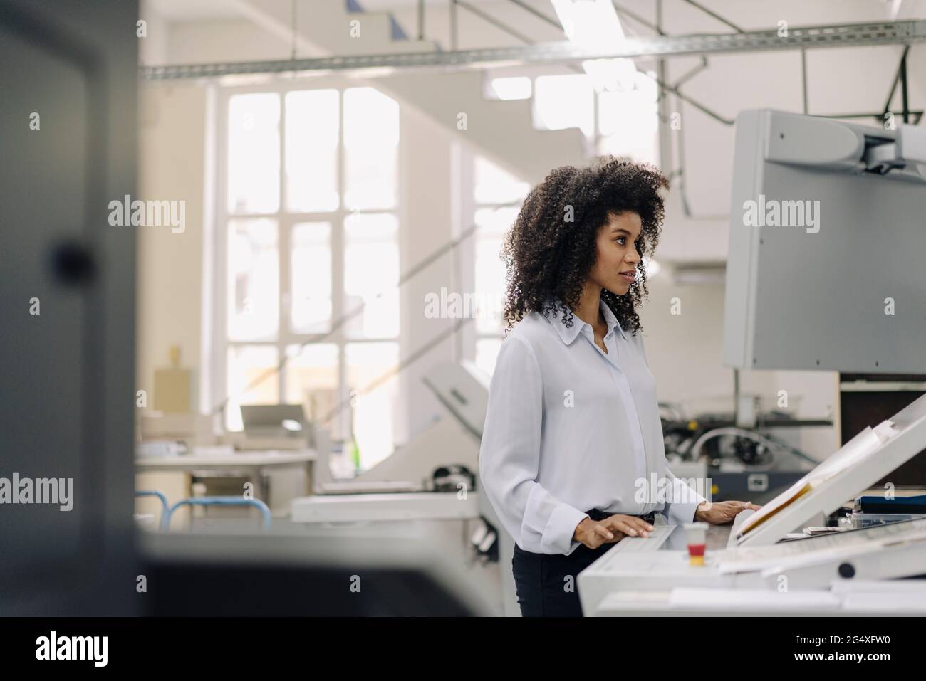 Female professional operating printing machine in industry Stock Photo ...
