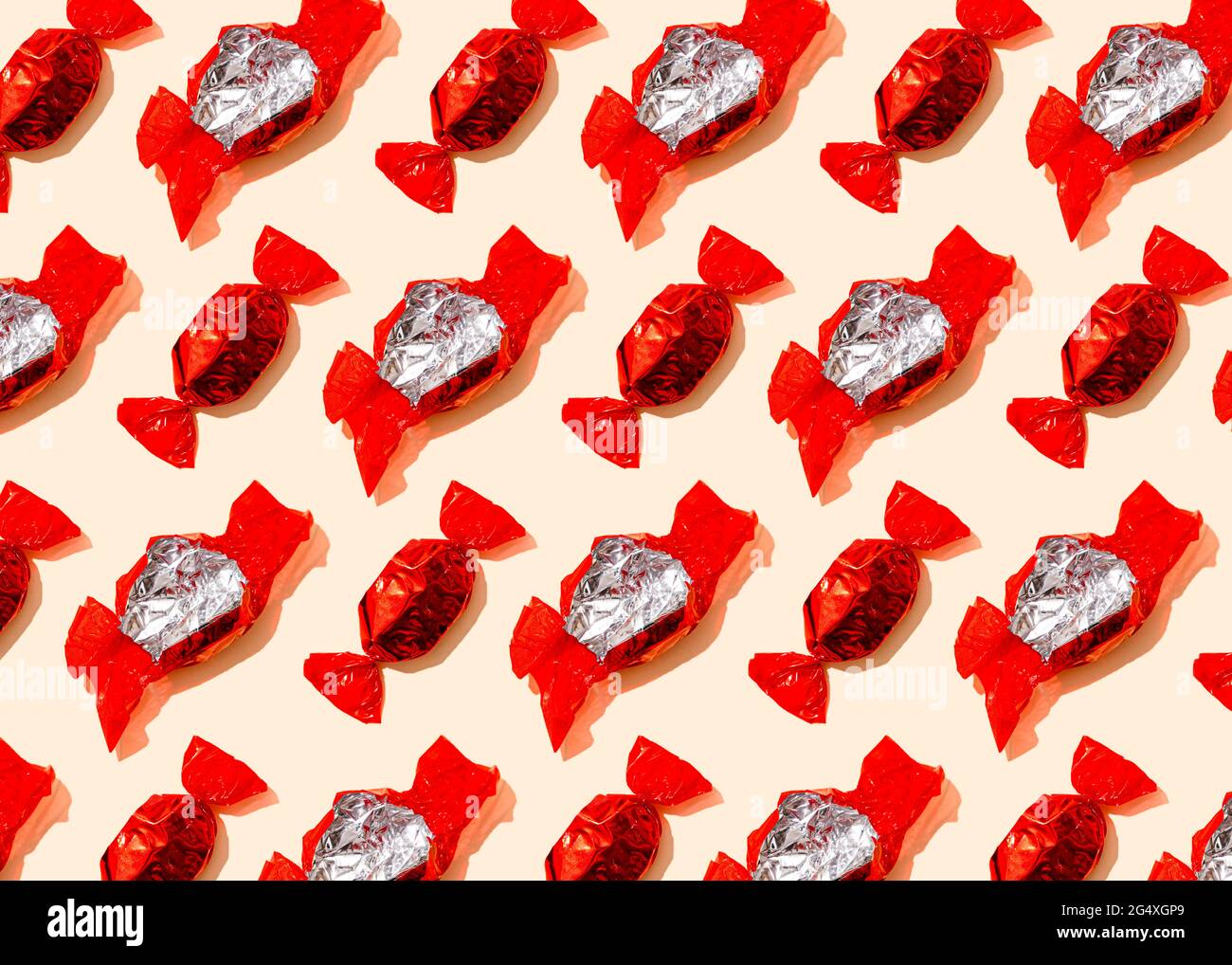 Pattern of rows of red wrapped candies and empty wrappers Stock Photo ...