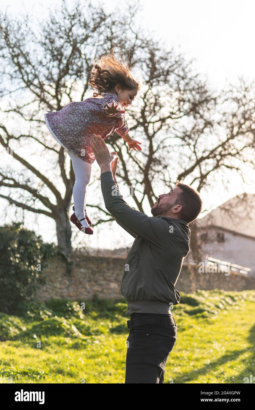 Father catching daughter while enjoying weekend during springtime Stock ...
