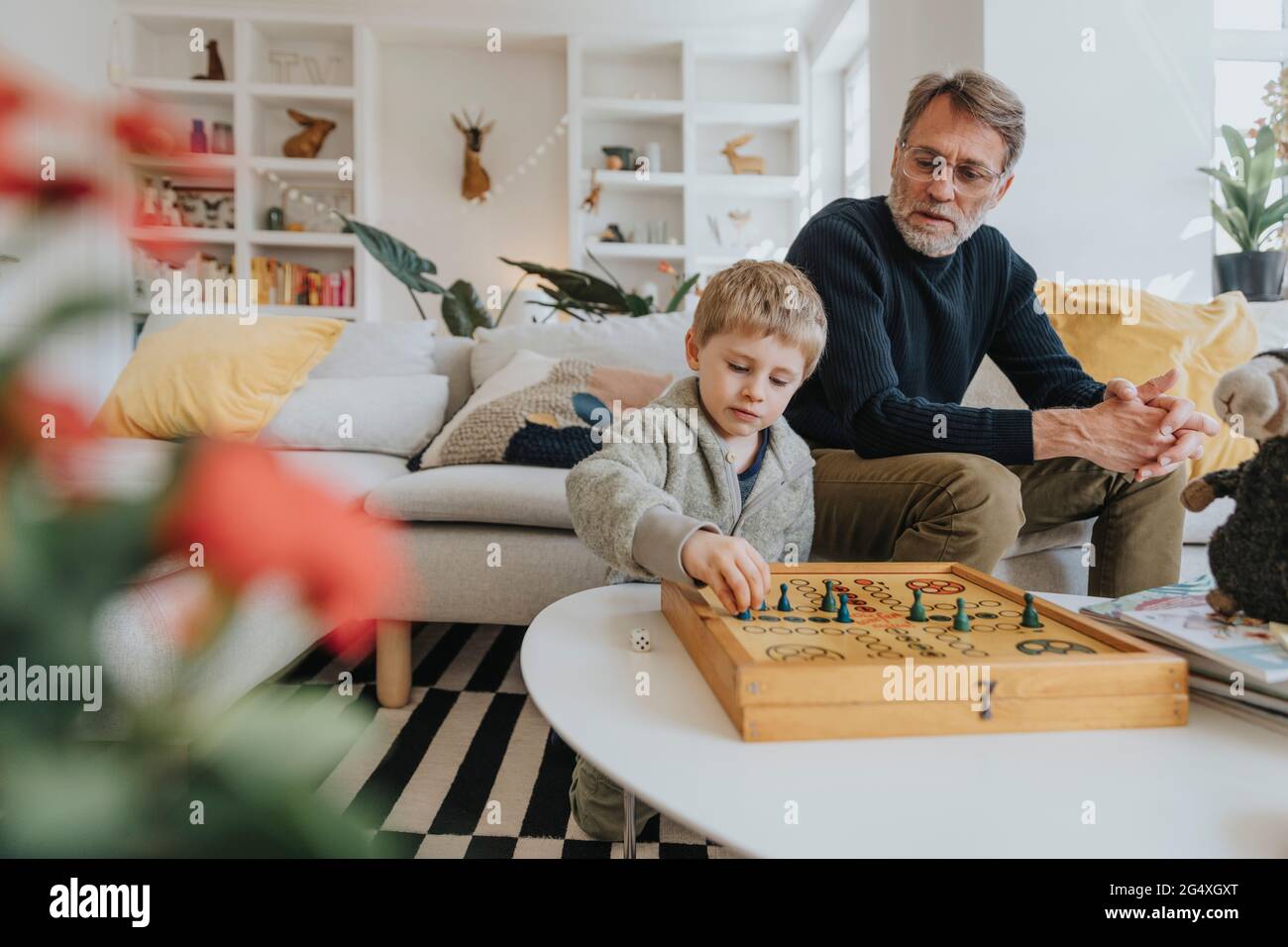 Father and son playing ludo in living room at home Stock Photo - Alamy