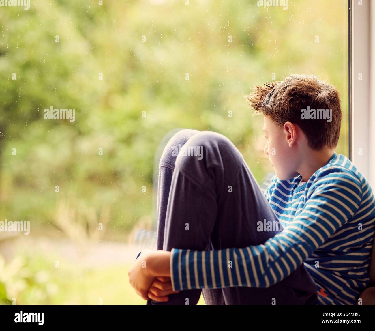 Boy looking through window hi-res stock photography and images - Alamy
