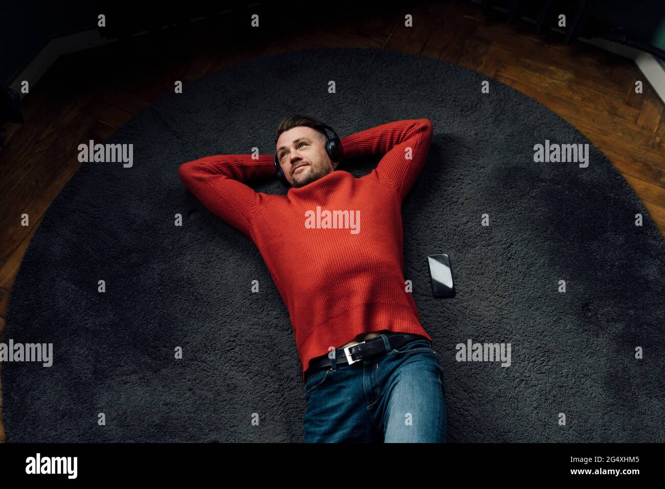 Male professional day dreaming while resting on carpet at workplace ...